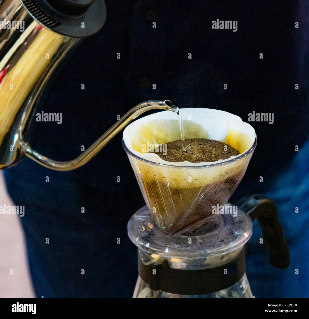 Drip coffee brewing, Barista pouring water on coffee ground with filter ...