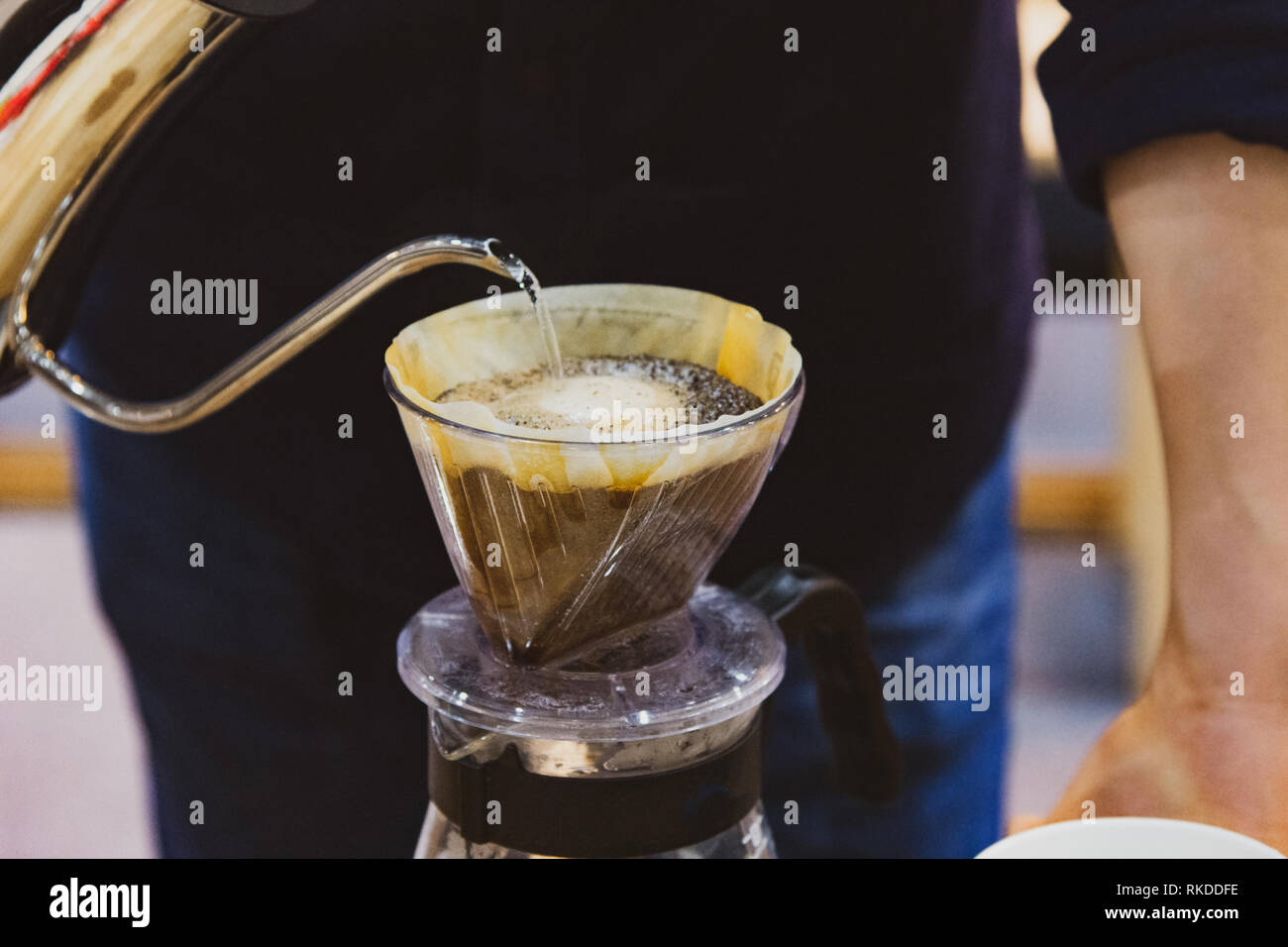 Drip coffee brewing, Barista pouring water on coffee ground with filter ...