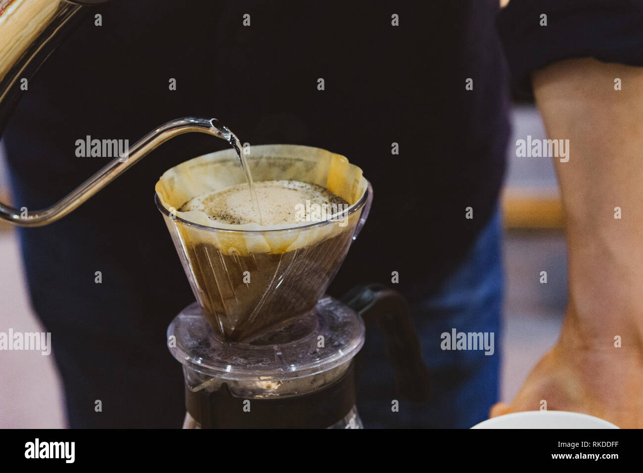 Drip coffee brewing, Barista pouring water on coffee ground with filter ...