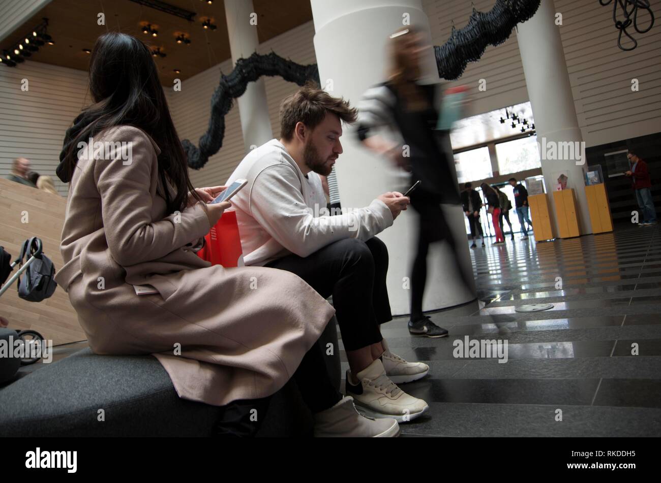 A man and woman take a seat in the lobby of the San Francisco Museum of ...