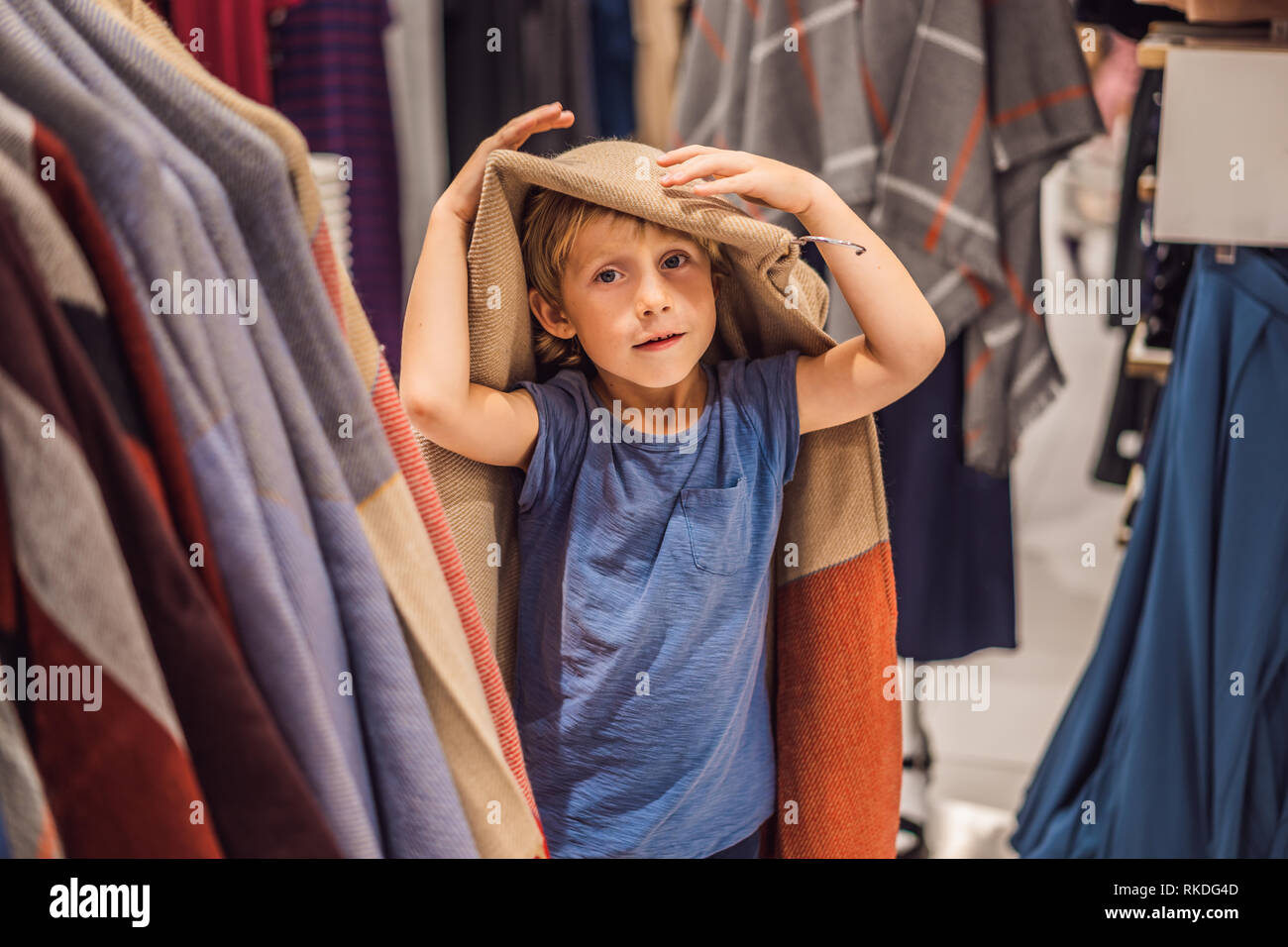 The boy tries on clothes in the childrens clothing store Stock Photo ...
