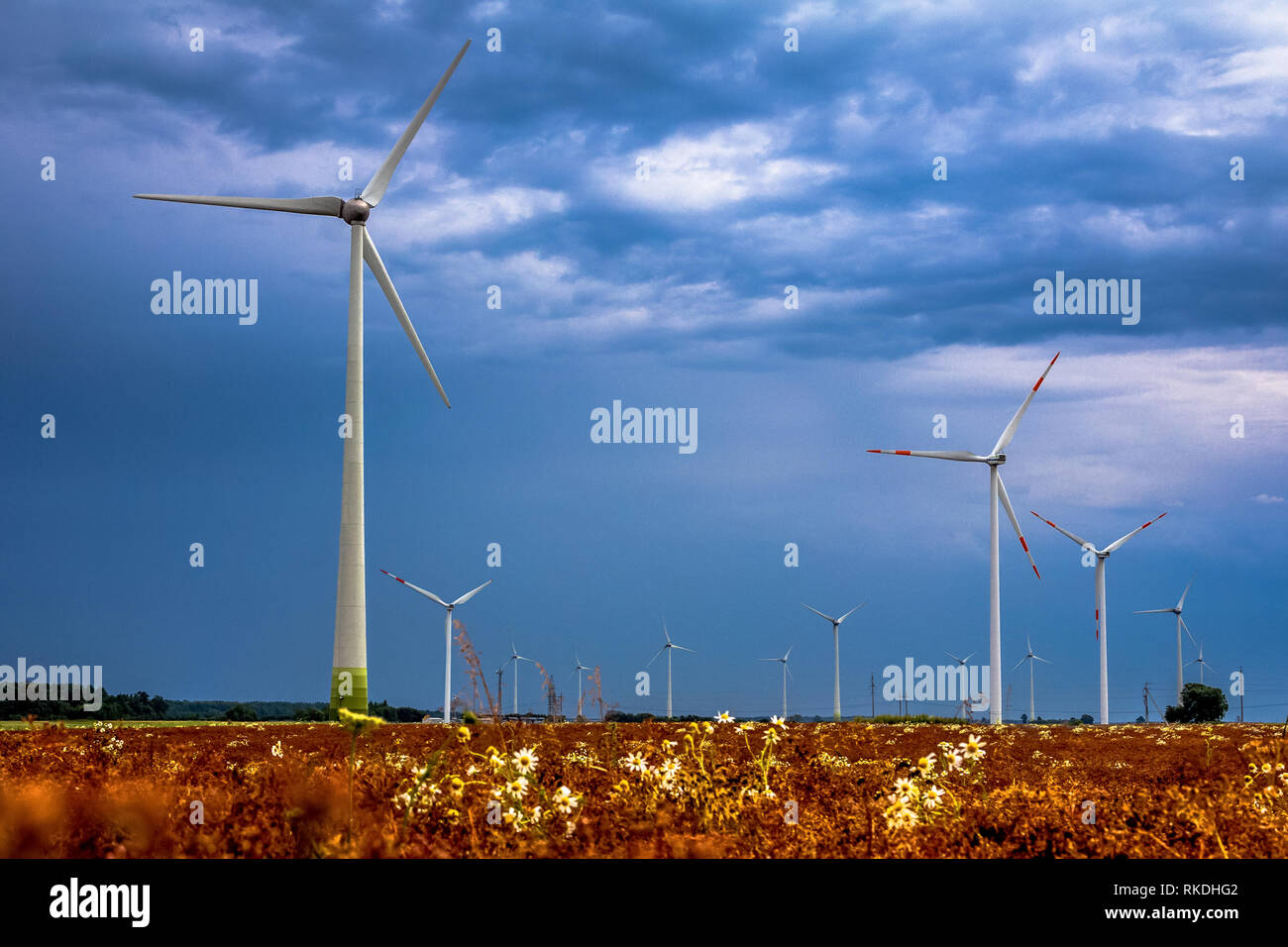 Windmills in the fields with dramatic rain clouds in the background ...