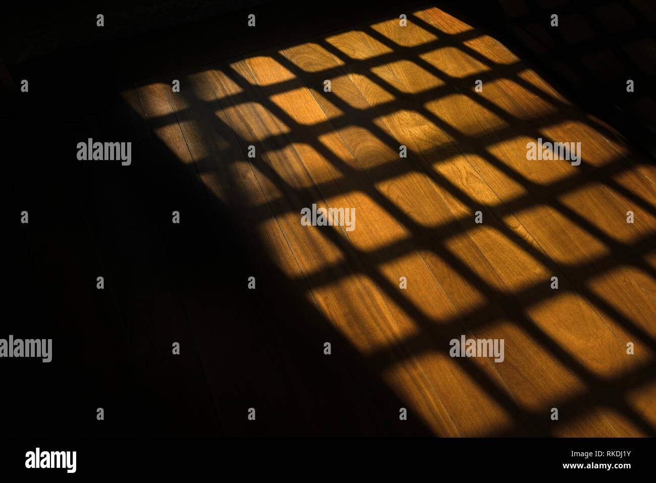 Dark window bars shadow on the wooden floor in prison Stock Photo - Alamy