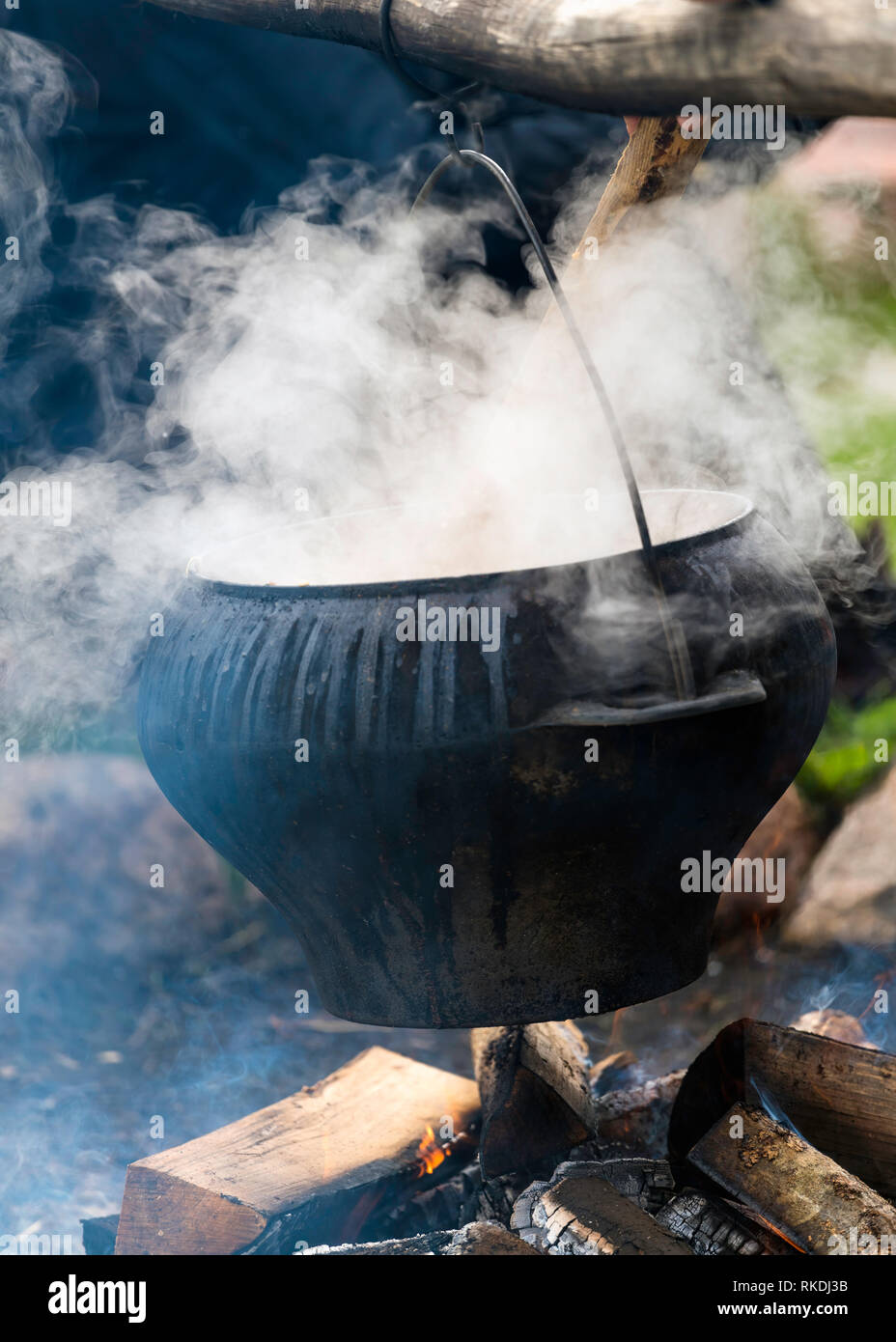 Big black cooking pot on fire outdoors Stock Photo - Alamy