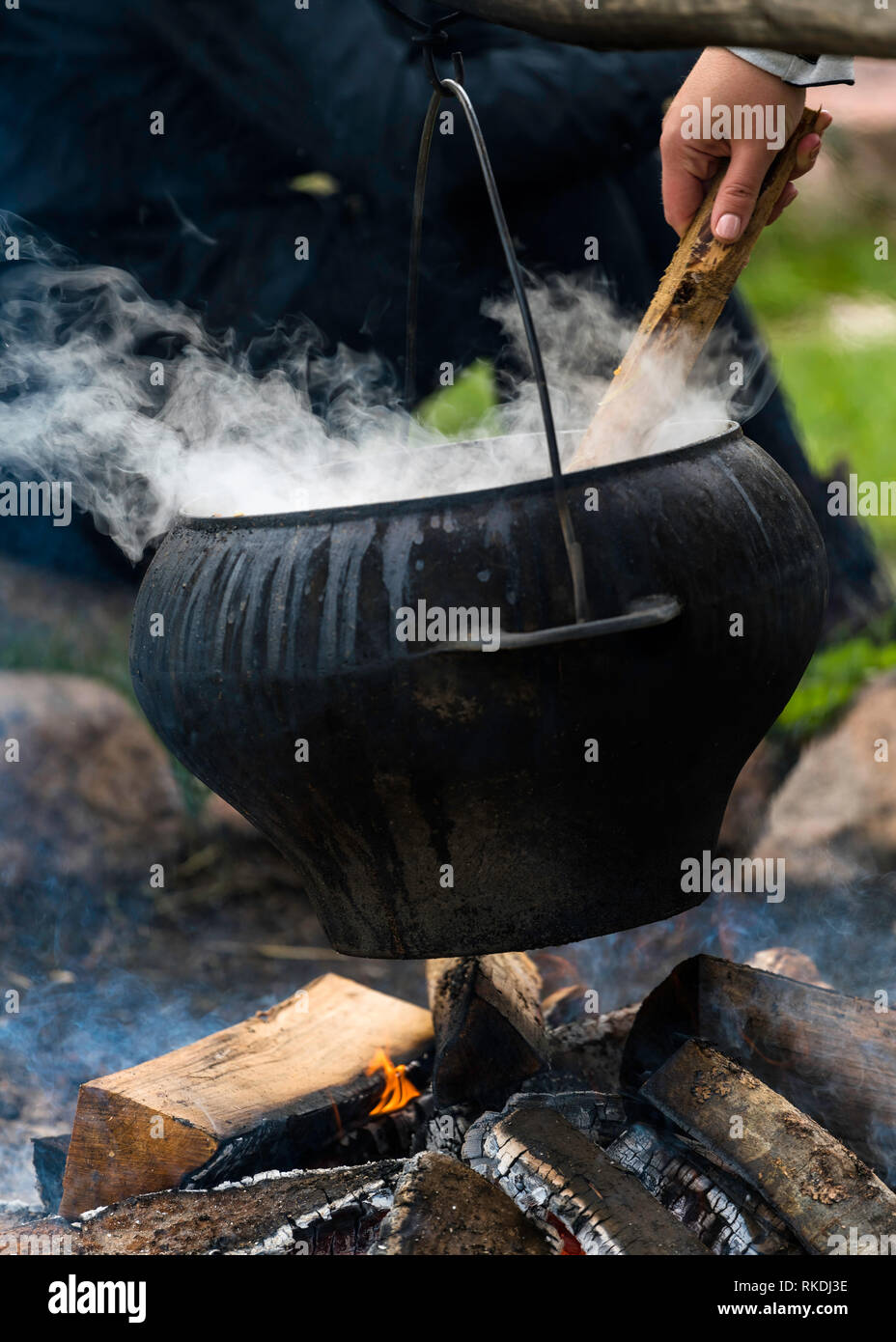 Big black cooking pot on fire outdoors Stock Photo - Alamy