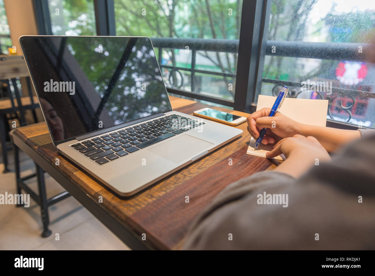 Asian student writing into notes Stock Photo - Alamy