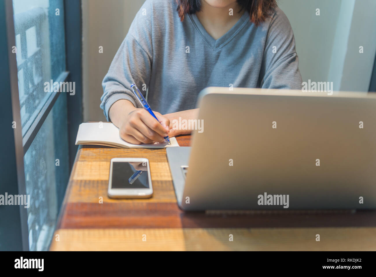 Young Asian student writing into the note Stock Photo - Alamy