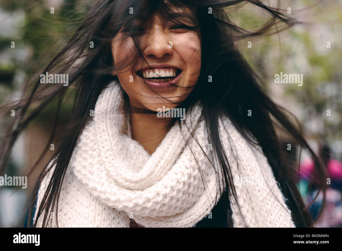 Close up of a woman standing outdoors with her hair covering her face ...
