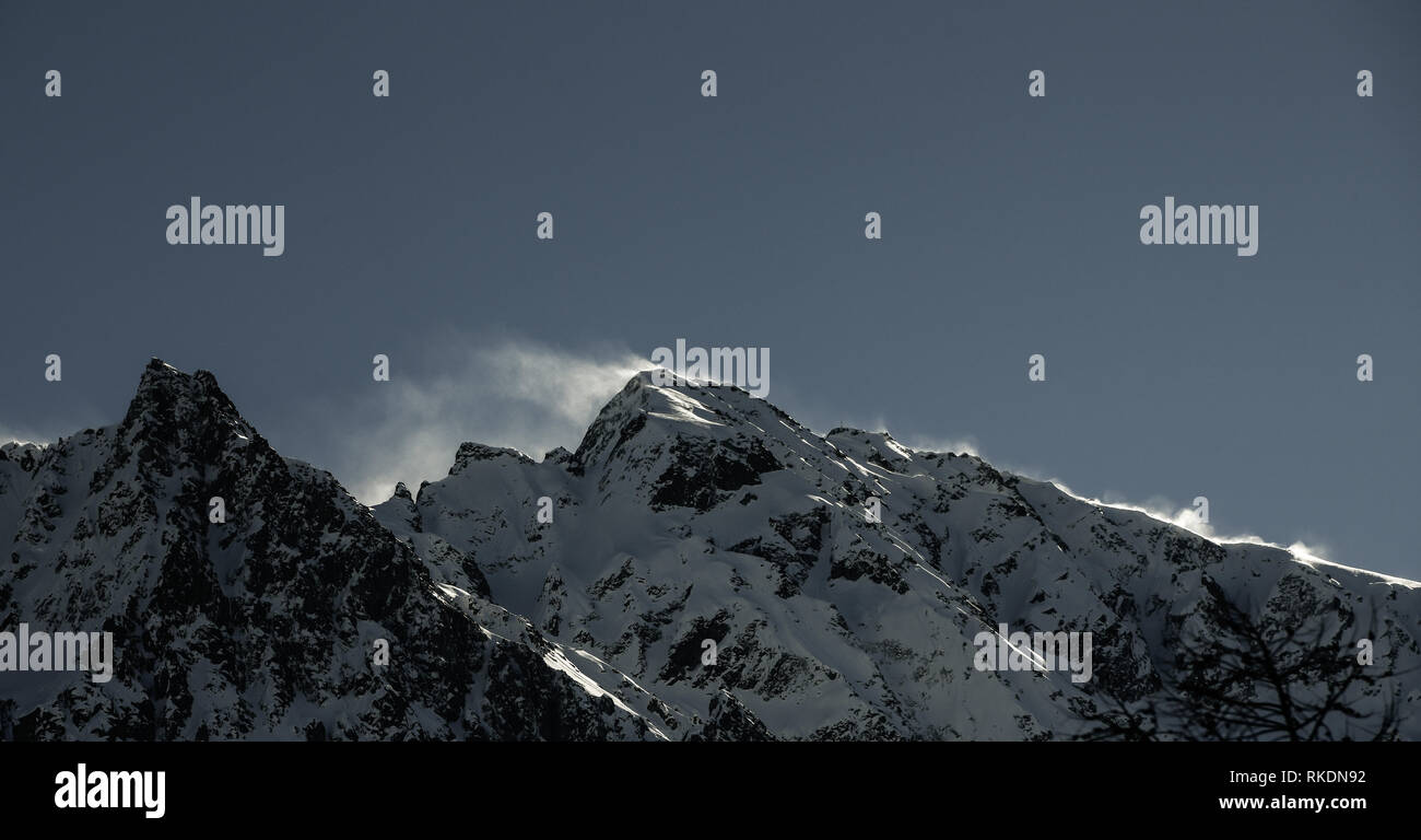 Wind blowing over snow capped mountain peaks Stock Photo - Alamy