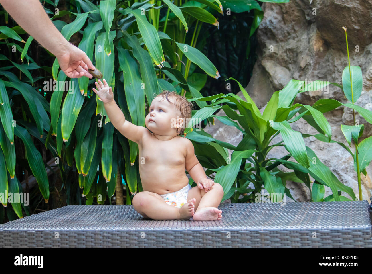 Portrait of a girl, reaching for the hand of dad for a drop The child ...