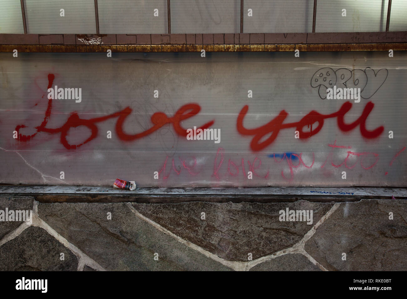 The phrase Love You is scrawled in red cursive script - Graffiti on a ...
