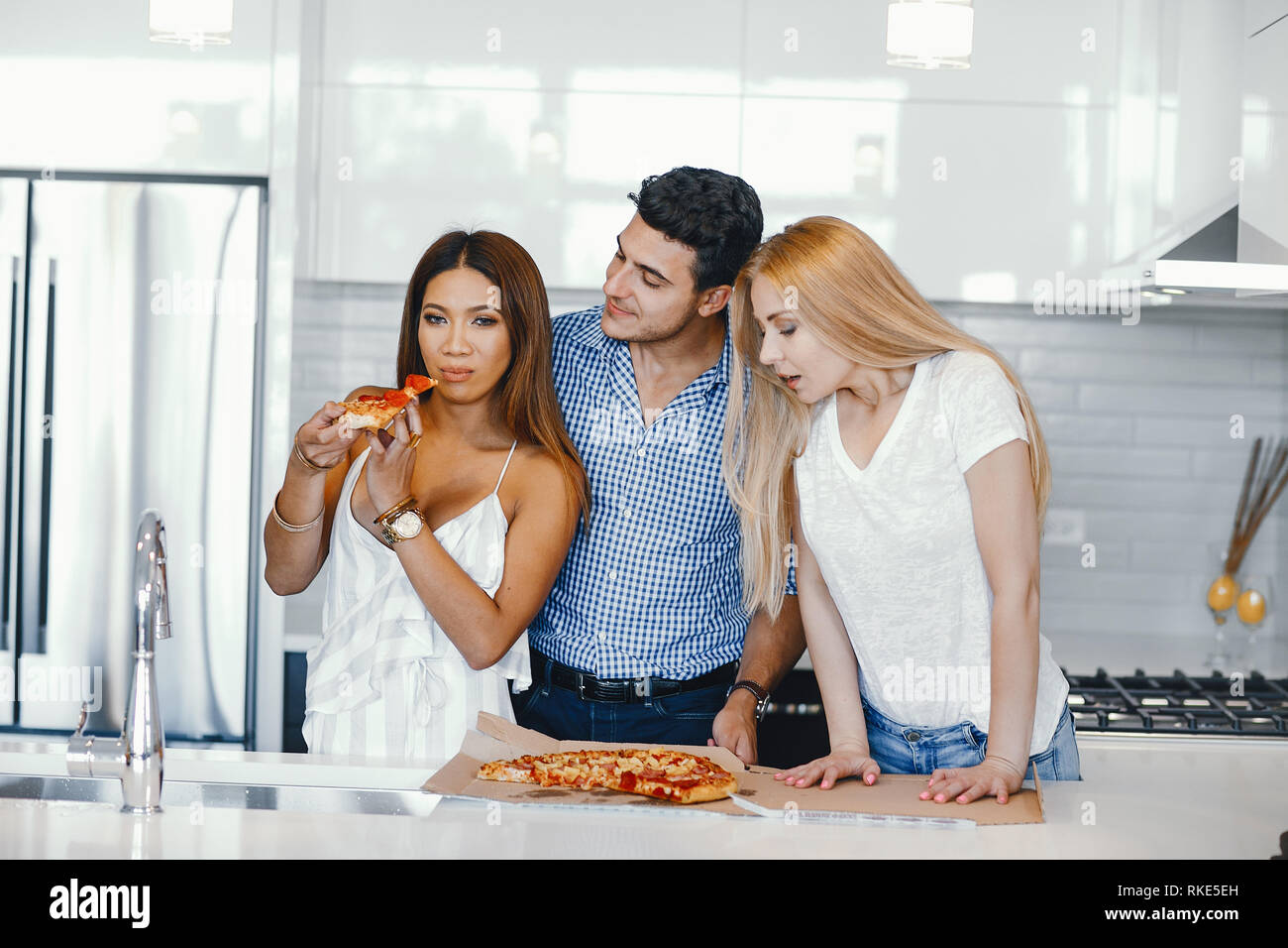 friends eating a pizza Stock Photo - Alamy