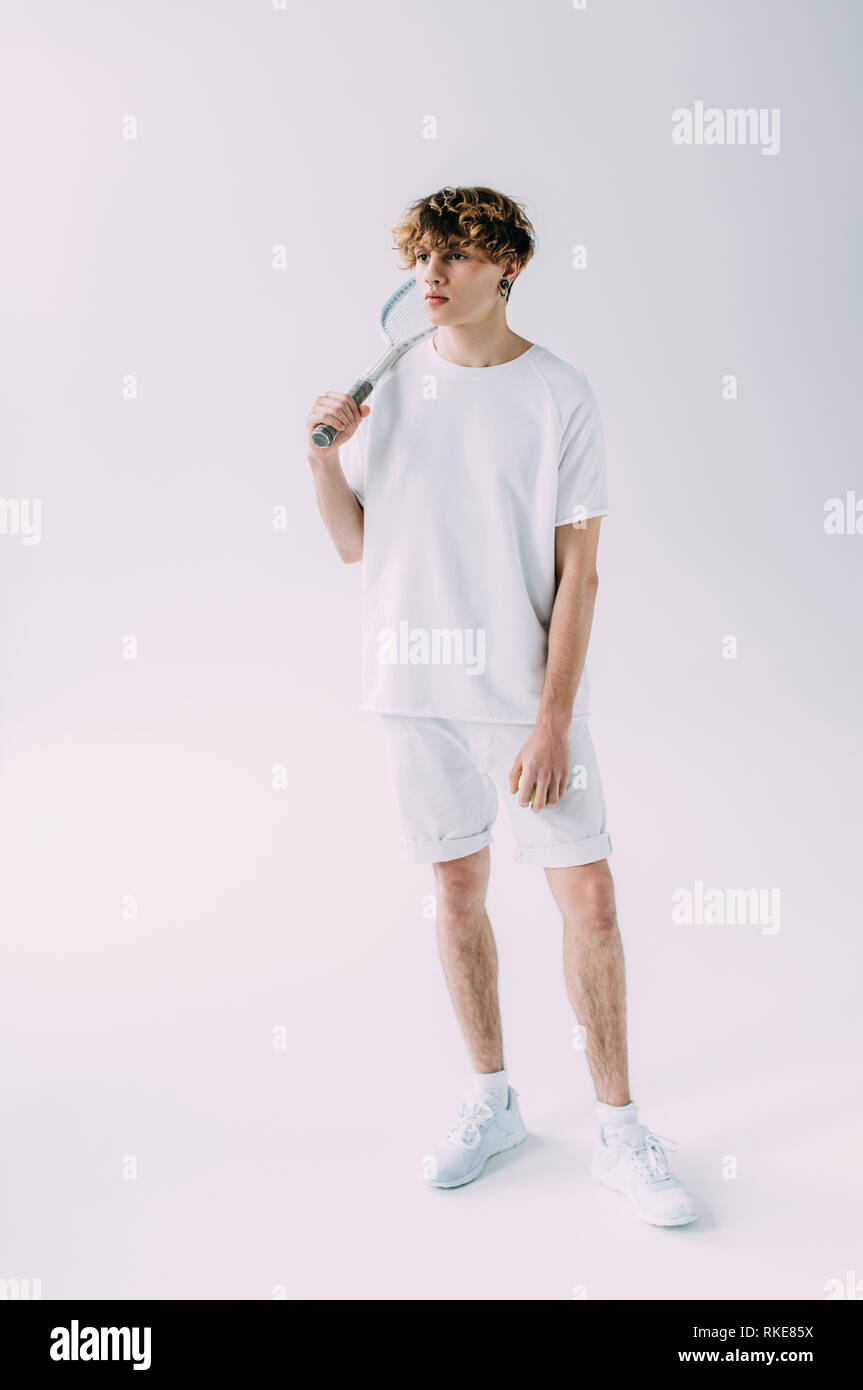 man with curly hair holding tennis racket isolated on grey Stock Photo ...