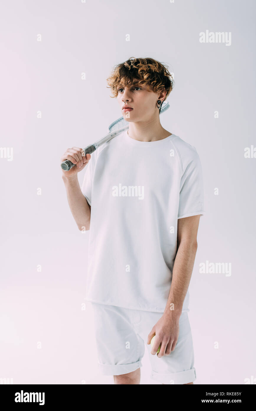 serious man with curly hair holding tennis racket isolated on grey ...