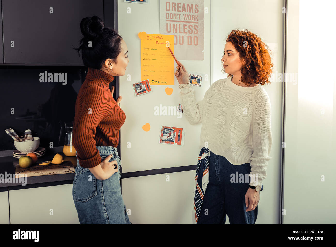 Women standing near fridge speaking about cleaning service Stock Photo ...