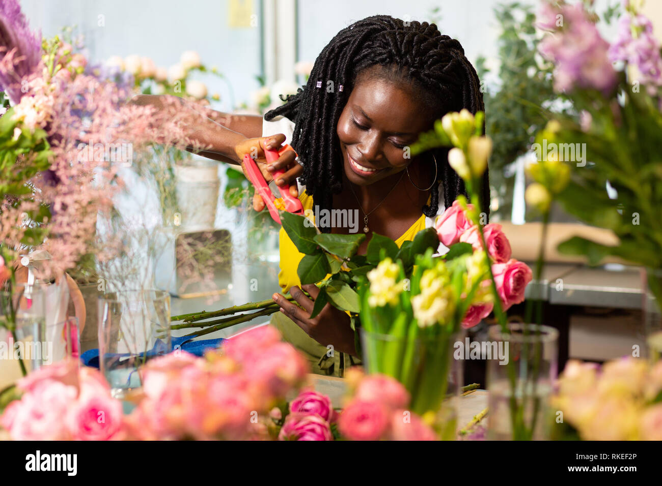 Beautiful international florist taking care of flowers Stock Photo - Alamy