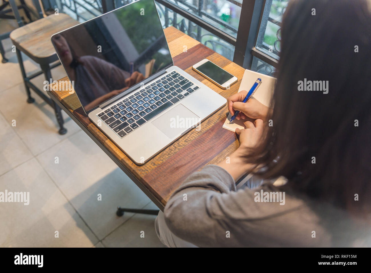 Asian student writing into the note Stock Photo - Alamy