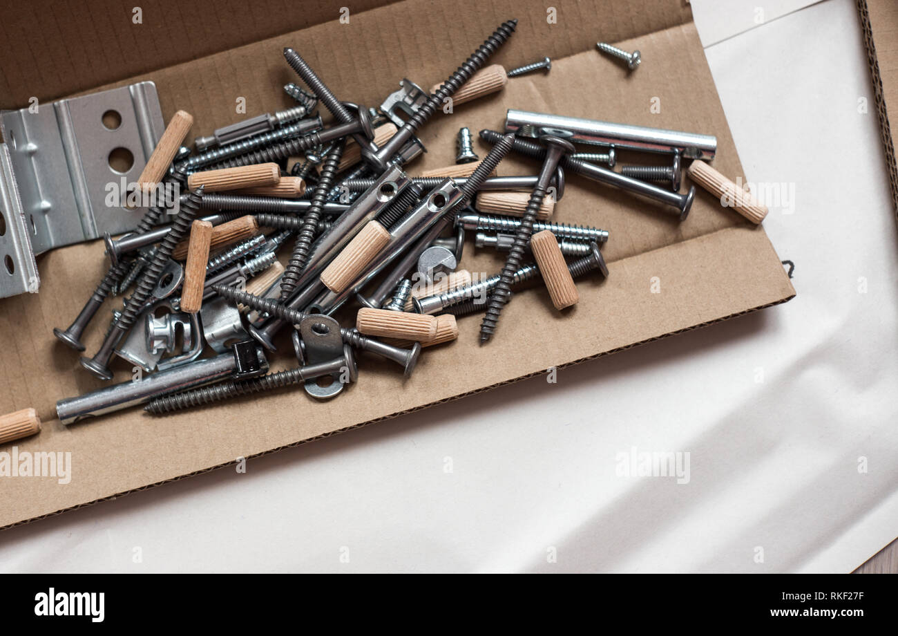 Furniture fittings, screws and other parts in open craft box lying on ...