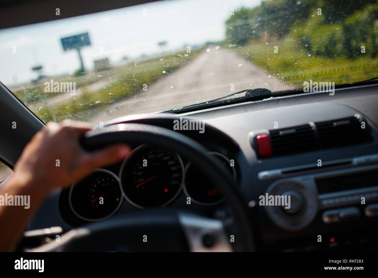 A man driving a car, focus on the left hand held on steering wheel ...