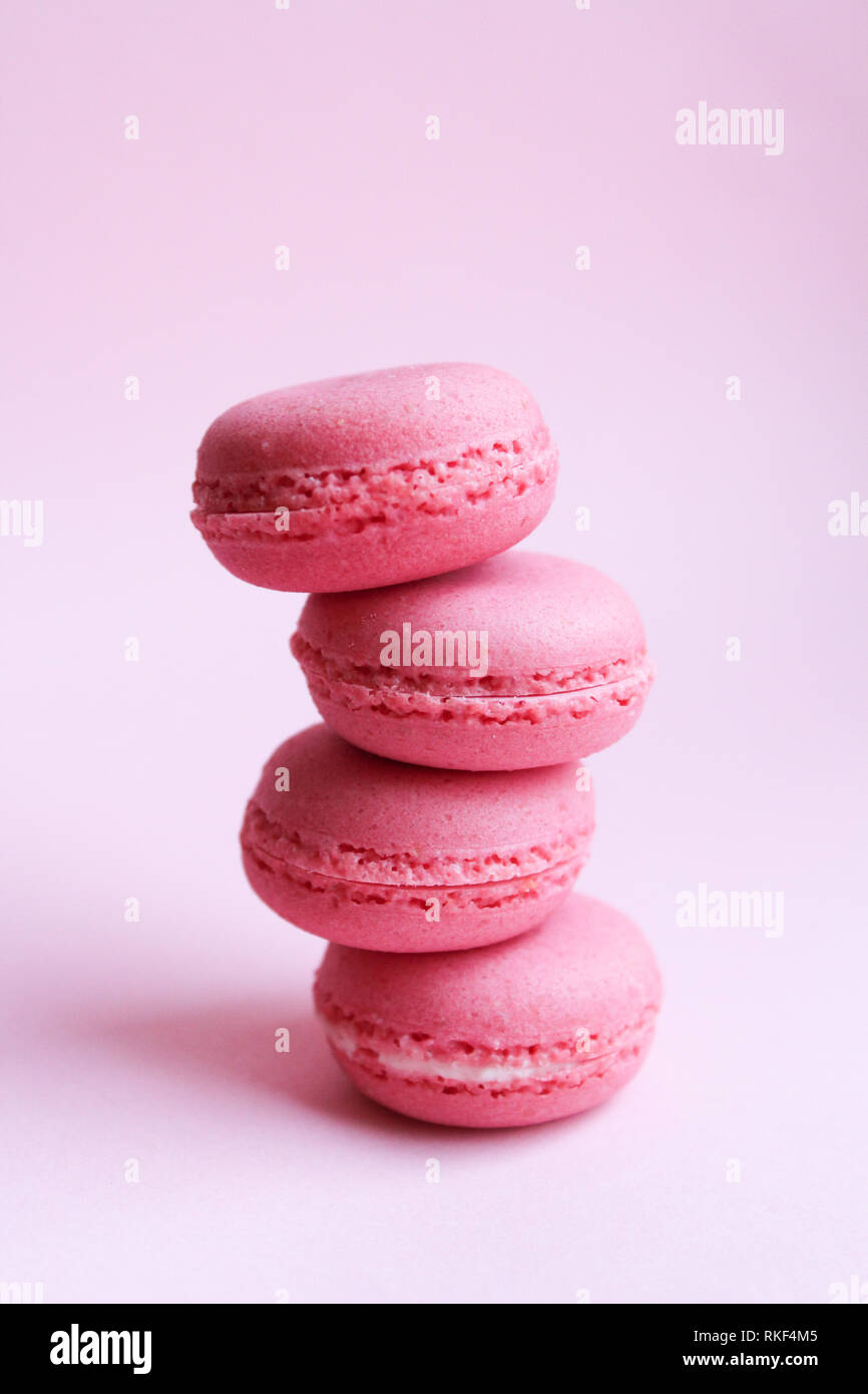 Four pink macaroons on a light pink background, minimal food concept ...