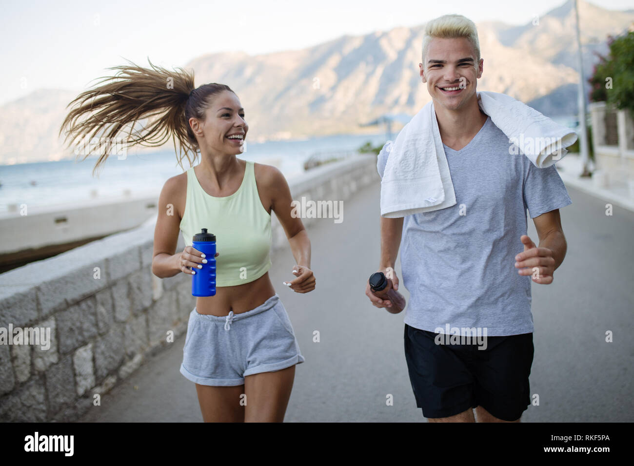 Happy fit people couple jogging and running outdoors Stock Photo - Alamy