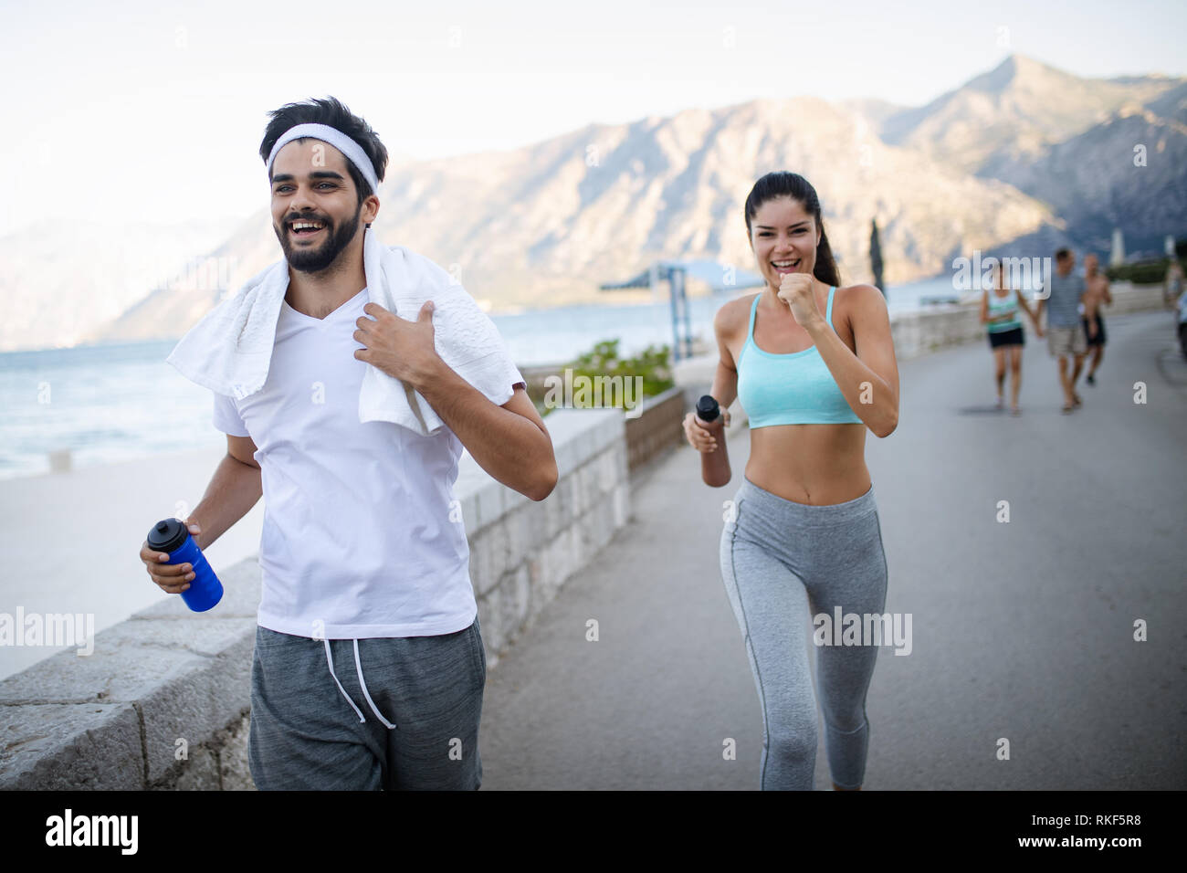 Happy young fit people couple running outdoor Stock Photo - Alamy