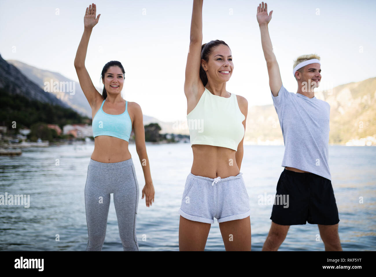 Fit group of happy people exercising outdoor. Smiling friends doing ...