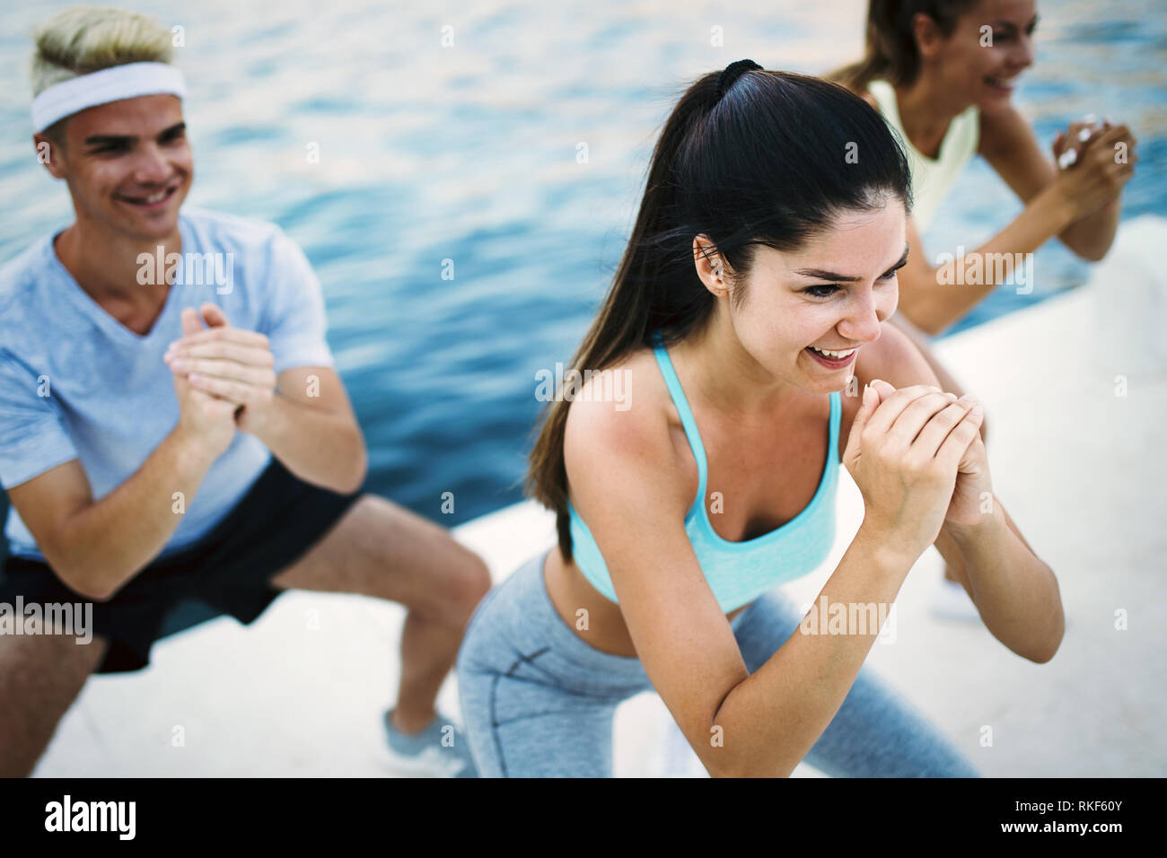 Group of happy friends or sportsmen exercising and stretching outdoor ...