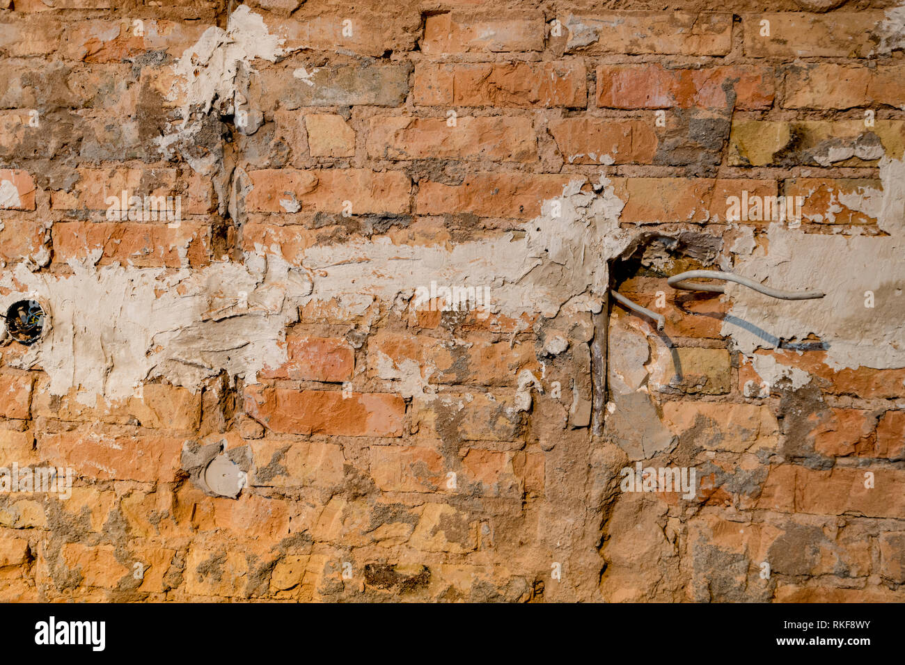 Brick wall with holes for power sockets and cables during a renovation ...