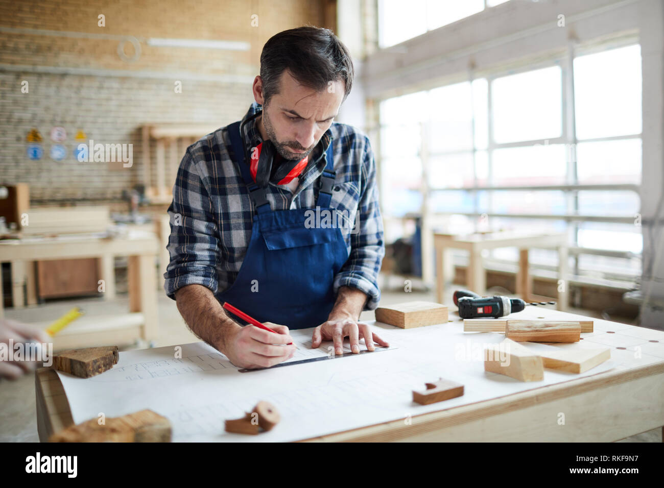 Thoughtful carpenter making sketch Stock Photo - Alamy