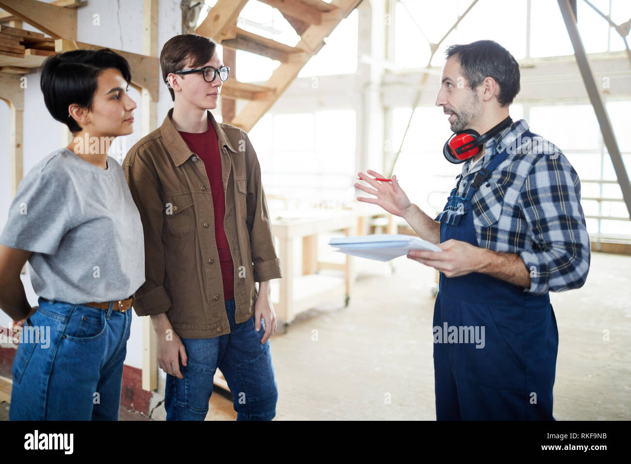 Builder talking to customers Stock Photo - Alamy