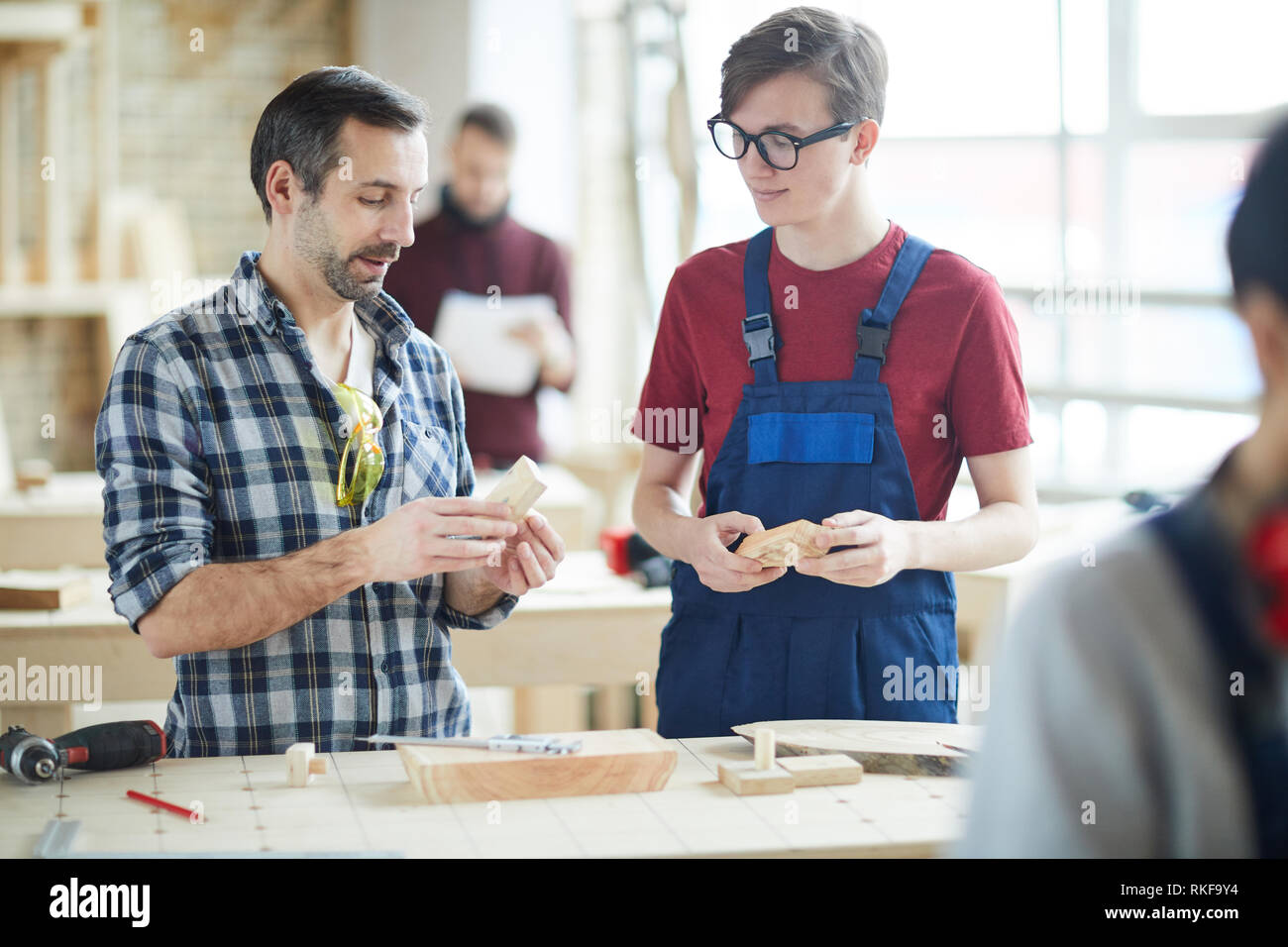 Professional carpenter giving advice to young guy Stock Photo - Alamy