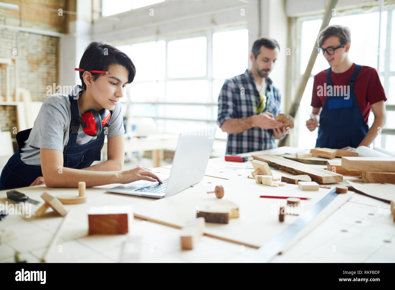 Concentrated lady joiner using internet on laptop Stock Photo - Alamy