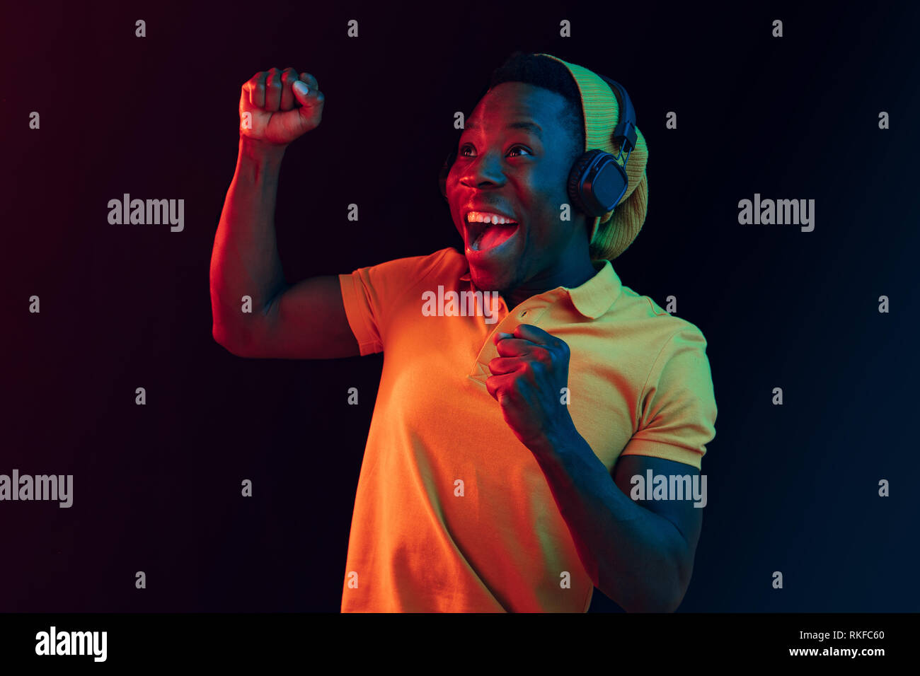 Young handsome happy hipster man listening music with headphones at ...