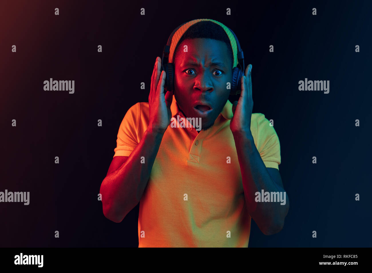 The young handsome happy hipster man listening music with headphones at ...