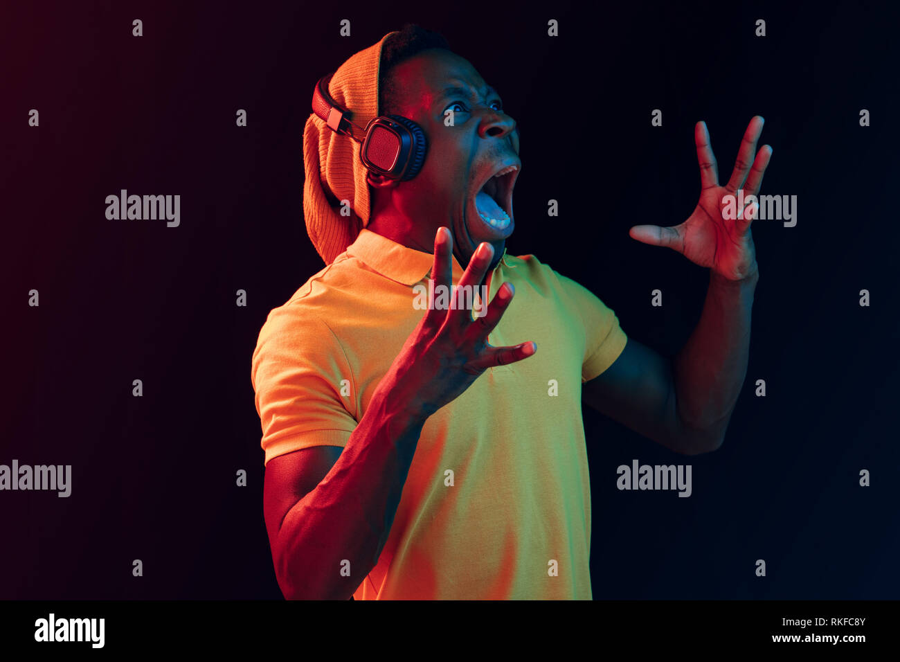 The young handsome happy hipster man listening music with headphones at ...