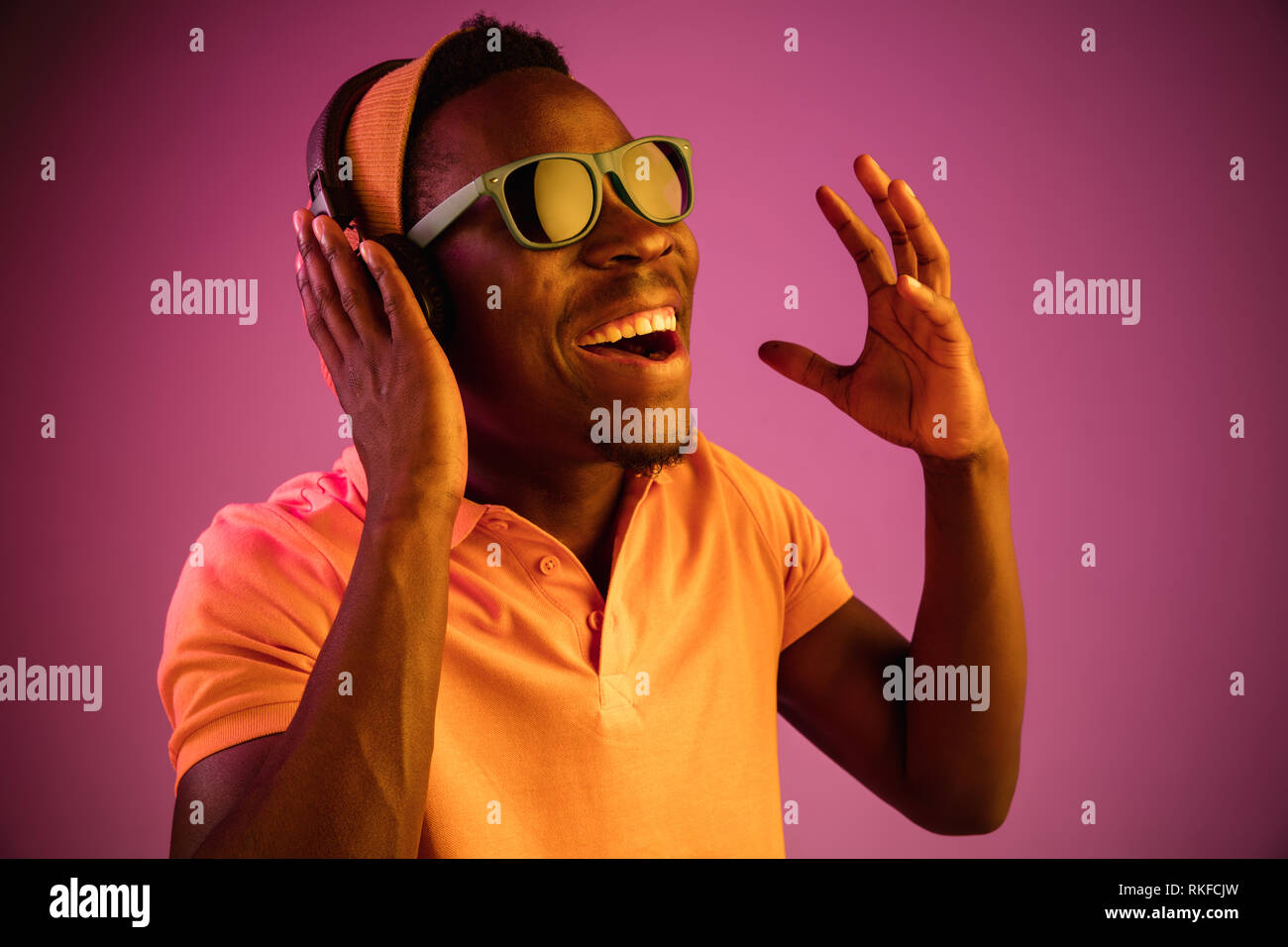 The young handsome happy hipster man listening music with headphones at ...