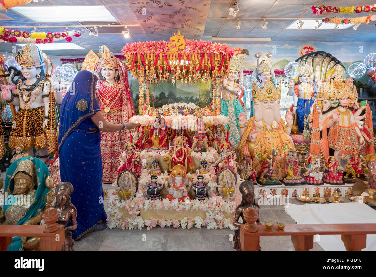 A devout Hindu woman performing aarti, the ritual of offering fire to ...