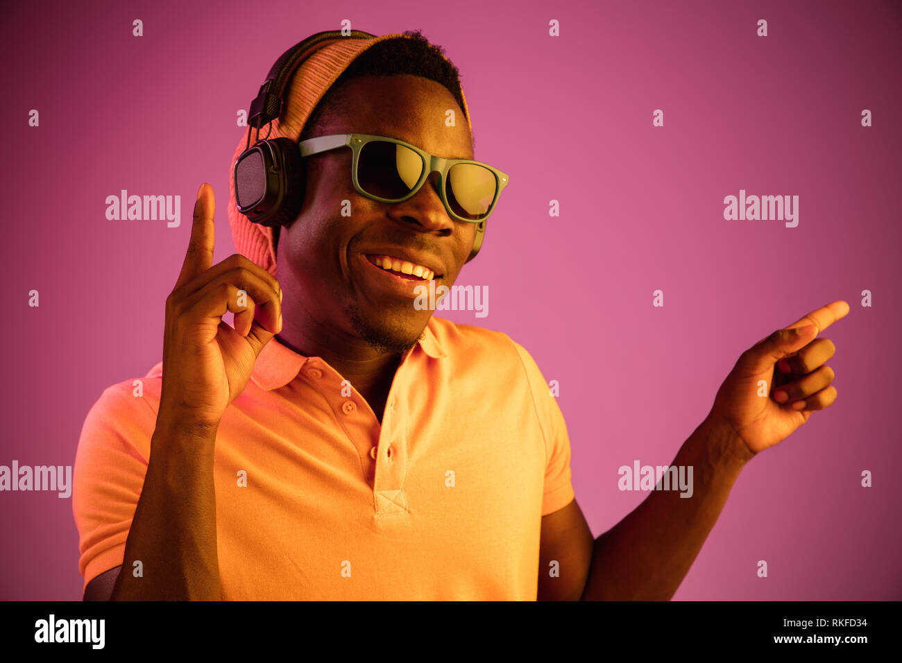 The young handsome happy hipster man listening music with headphones at ...