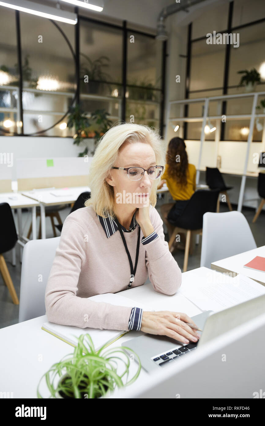 Concentrated lady manager using laptop Stock Photo - Alamy