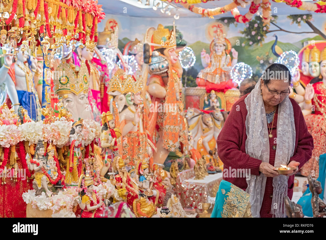 A devout Hindu woman performing aarti, the ritual of offering fire to ...