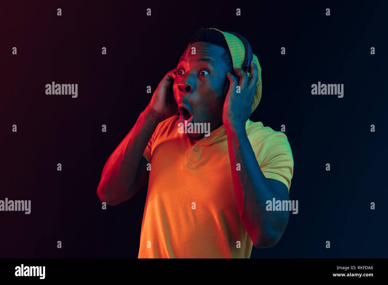 Young handsome happy hipster man listening music with headphones at ...