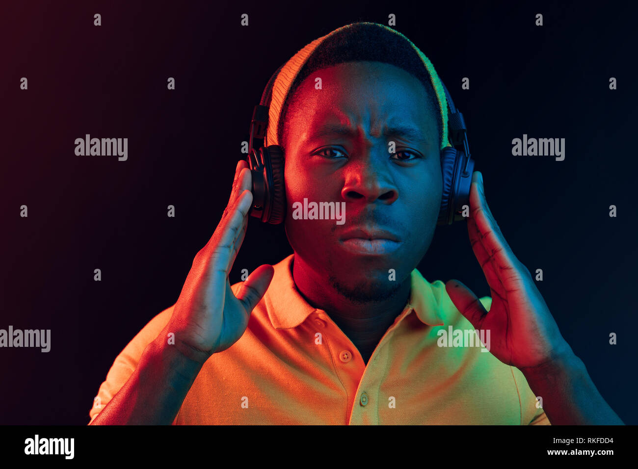 The young handsome serious sad hipster man listening music with ...