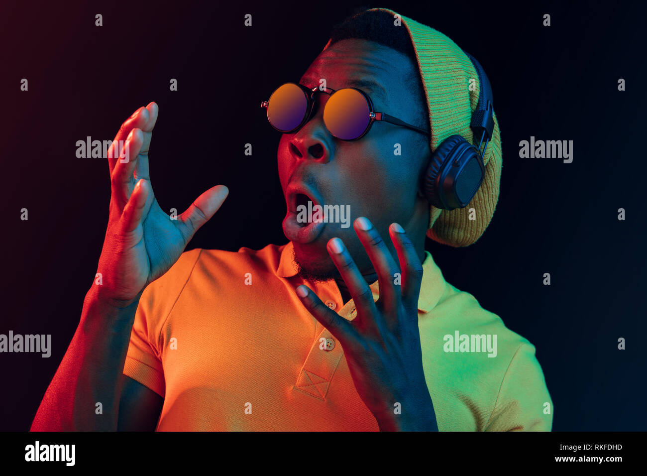 Young handsome serious sad hipster man in sunglasses listening music ...