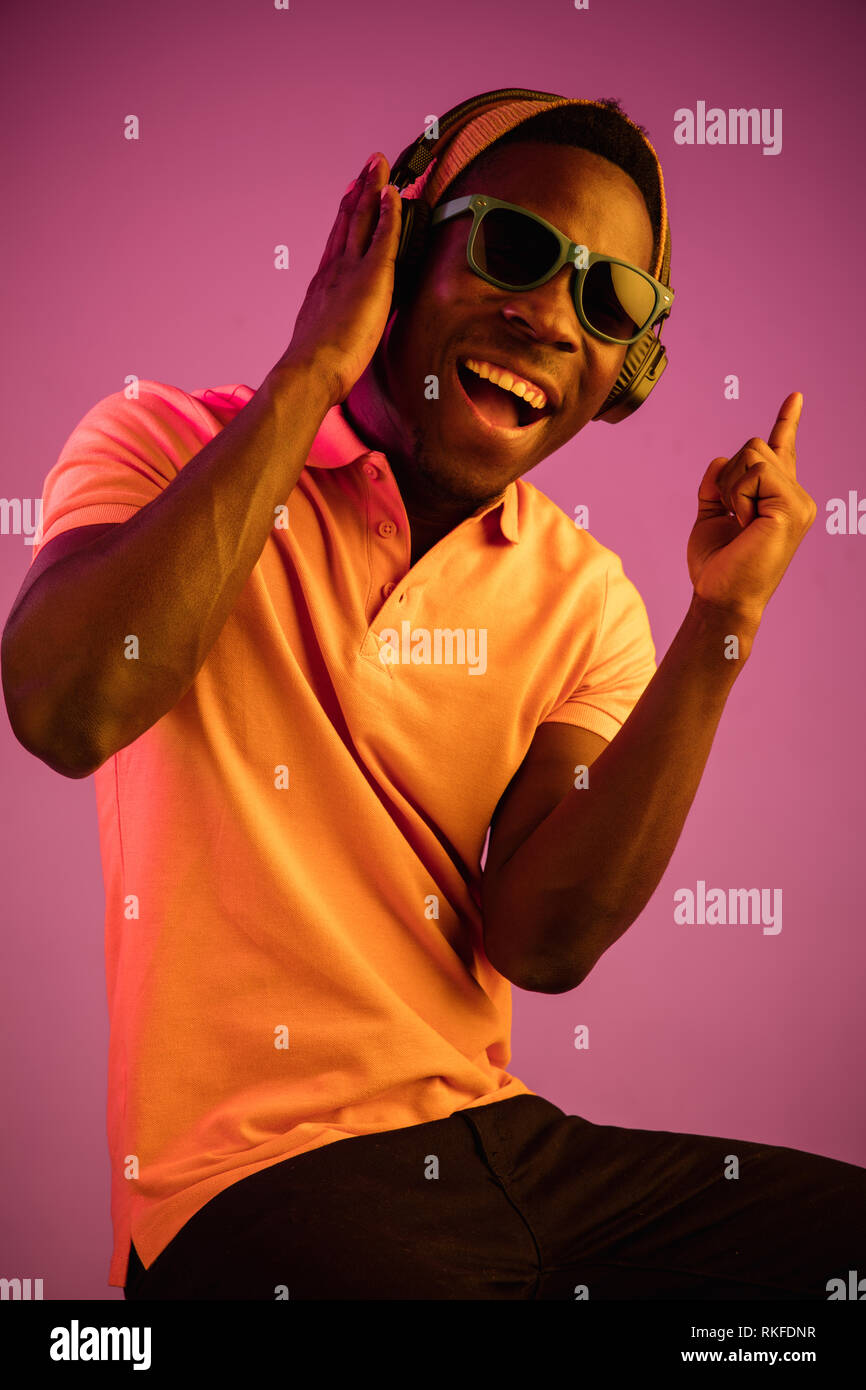 The young handsome happy hipster man listening music with headphones at ...