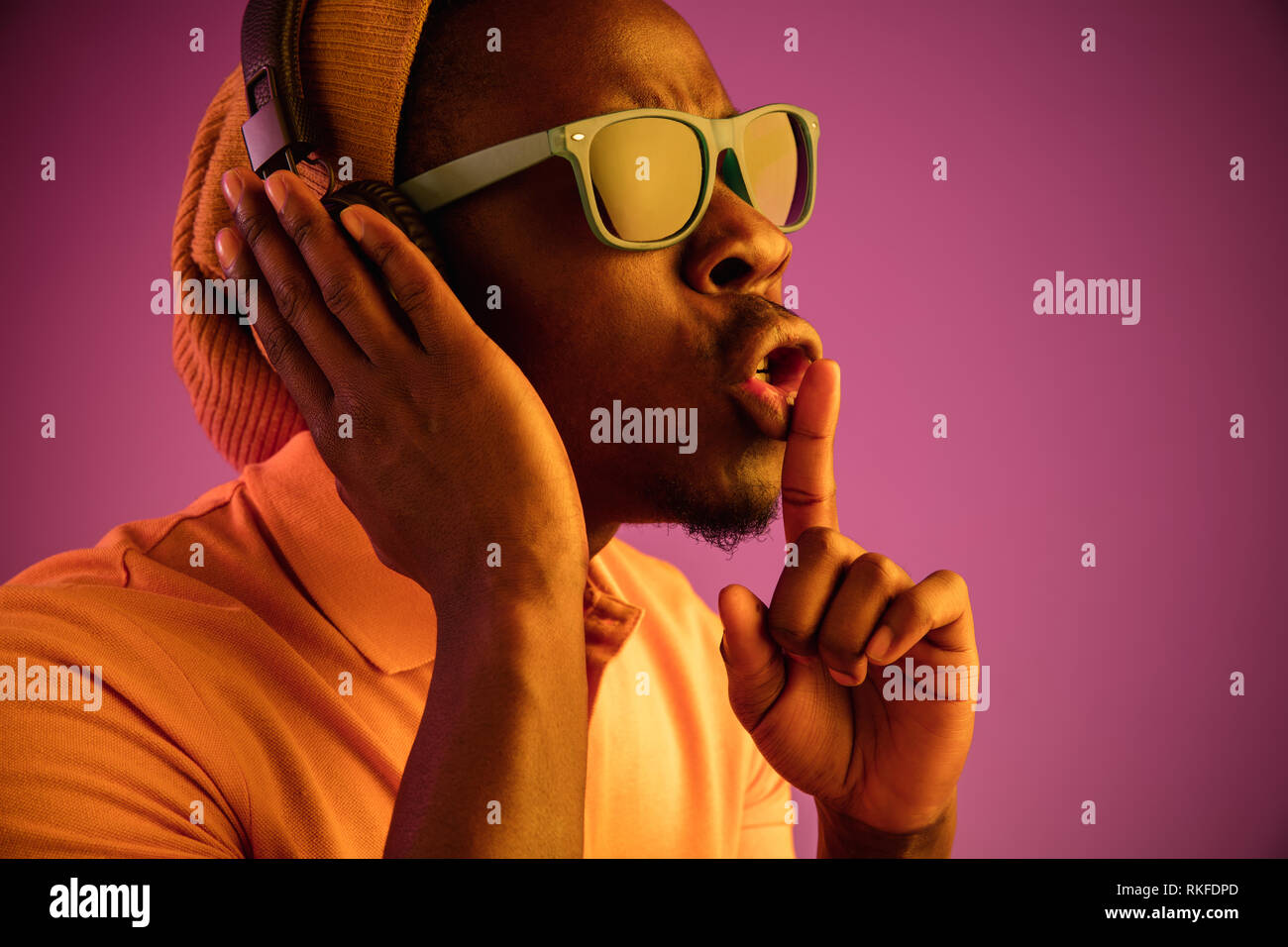 The young handsome happy hipster man listening music with headphones at ...