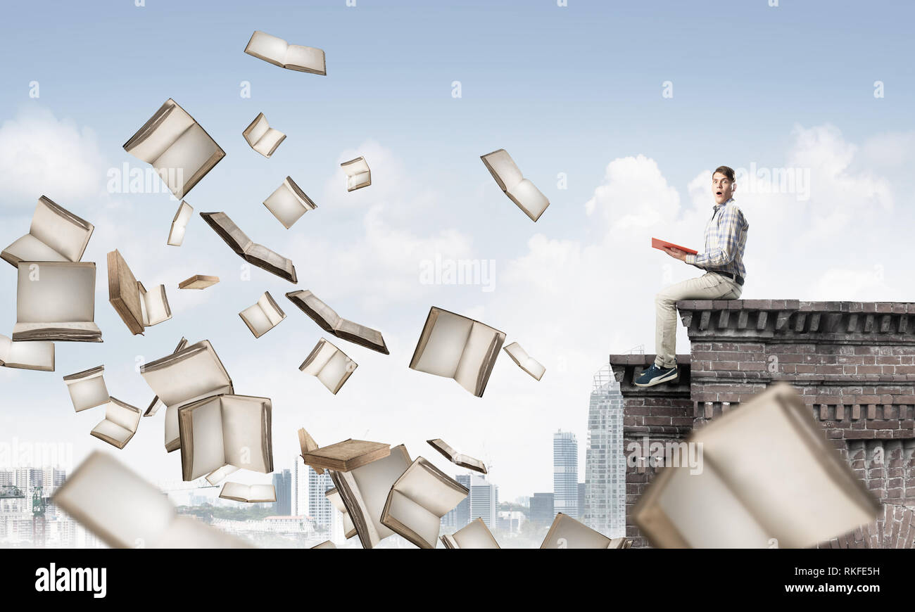 Man reading book and many of them flying in air Stock Photo - Alamy