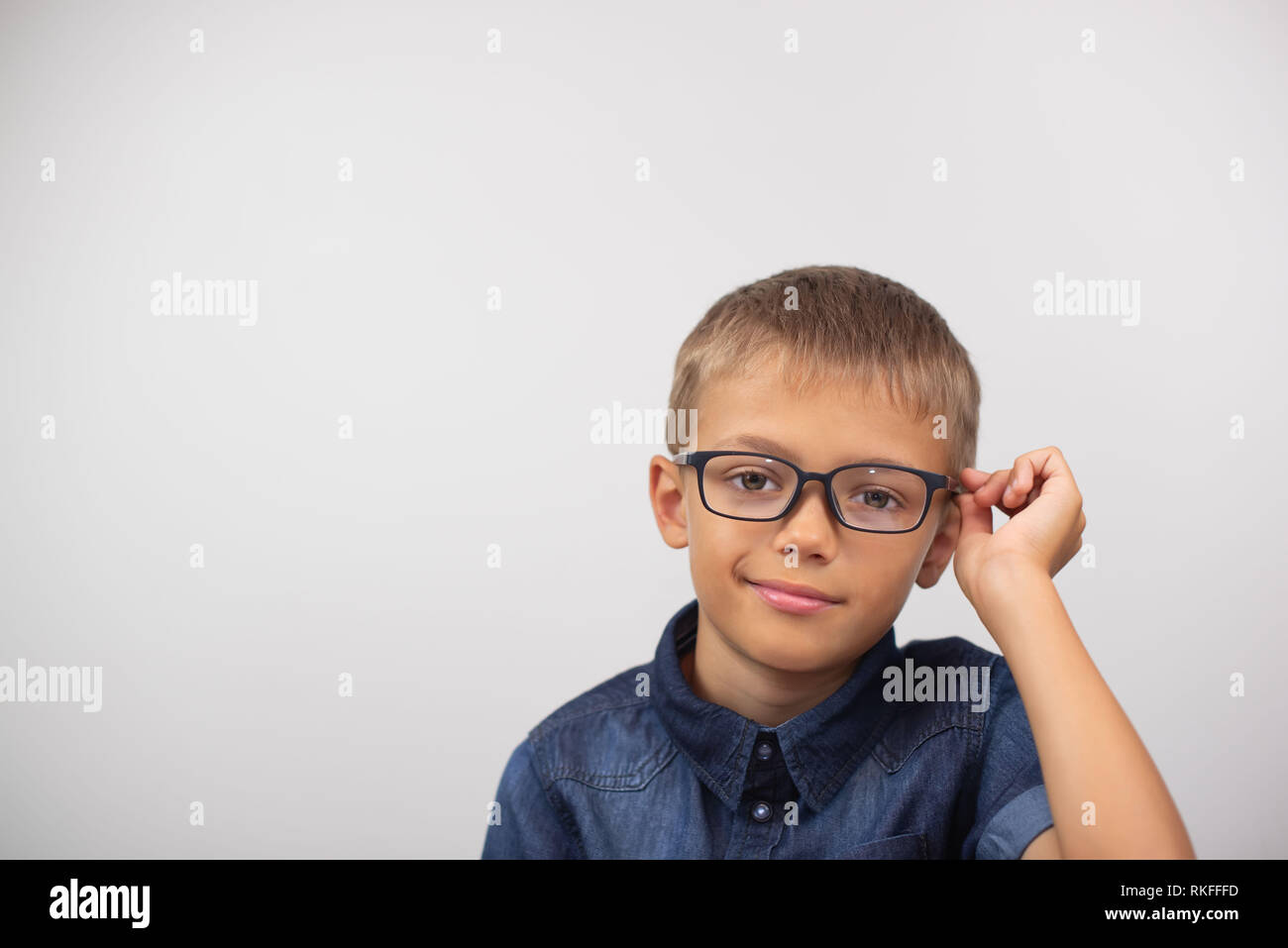 Boy student sitting at a table on a light background. Concept back to ...