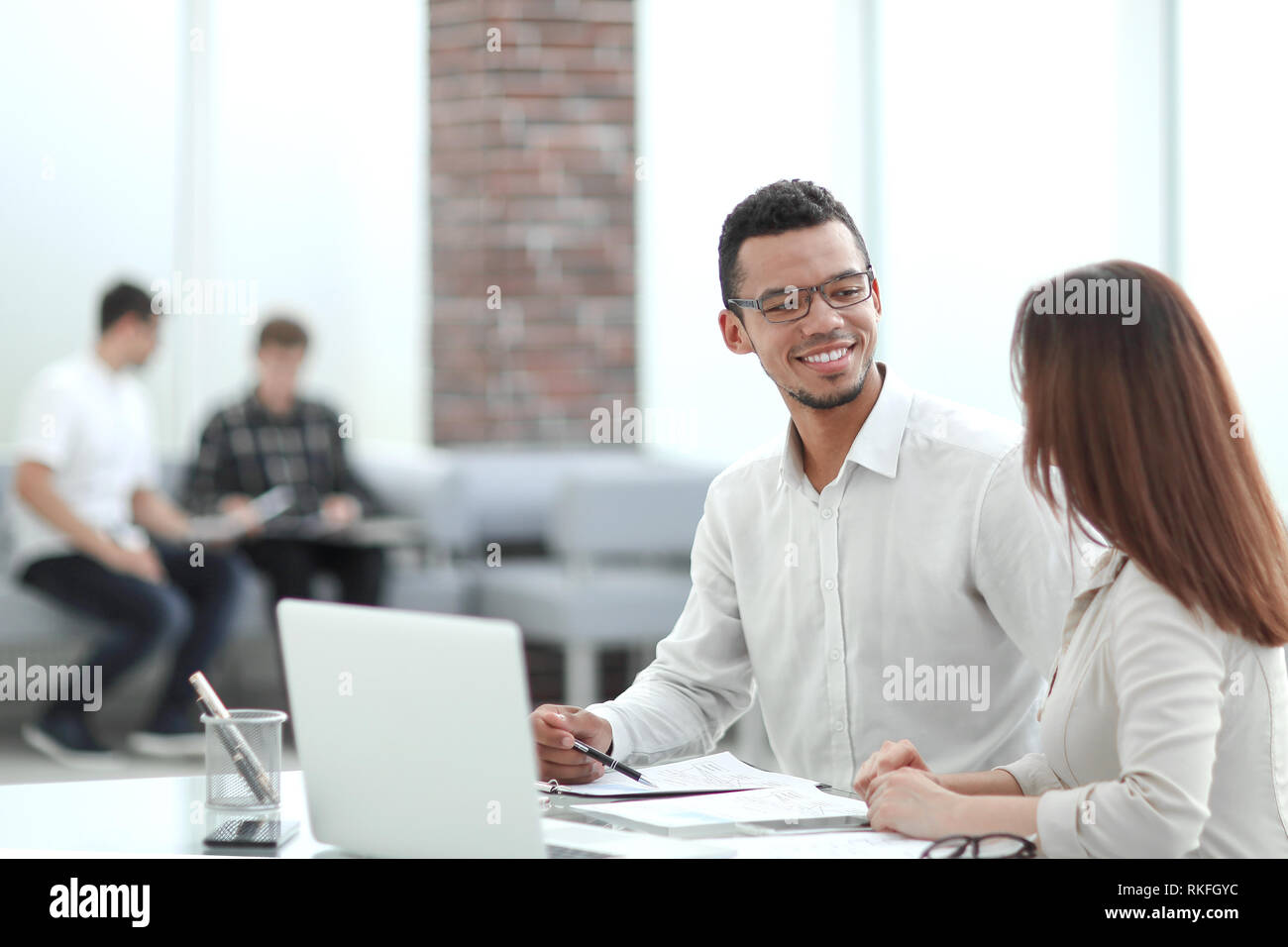 employees sitting at a table in the office Stock Photo - Alamy