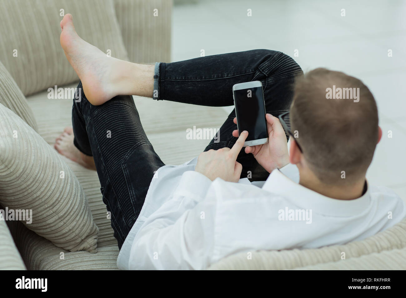 rear view.young man looking through a text on his smartphone Stock ...